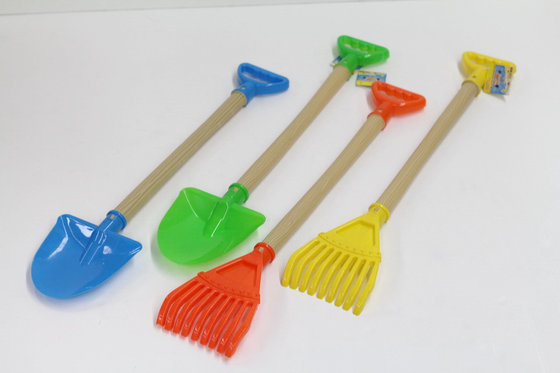 La spiaggia di plastica della mini sabbia spala i rastrelli, i giocattoli di plastica dei bei bambini